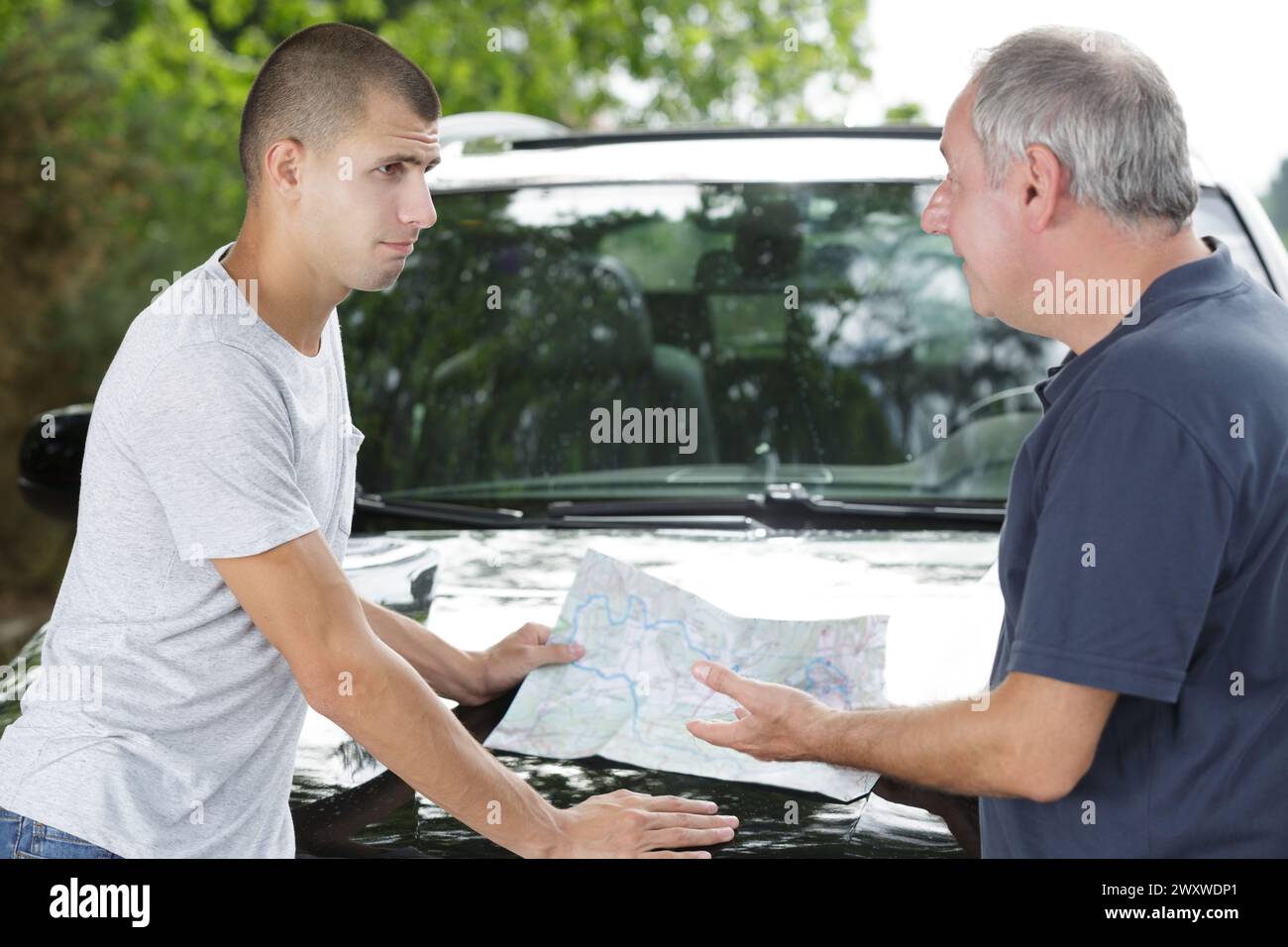 people checking the map for direction on road trip Stock Photo - Alamy