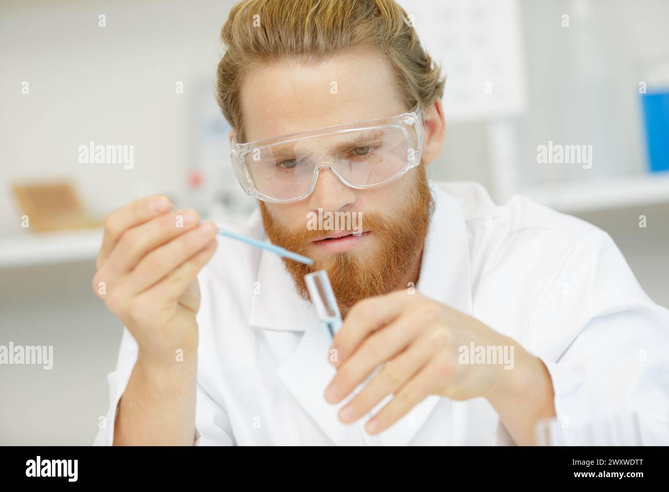 man in lab coat holding a pipette Stock Photo - Alamy