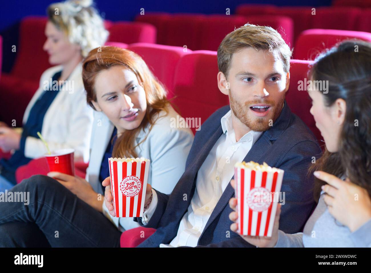 smiling friends talking in the cinema Stock Photo - Alamy