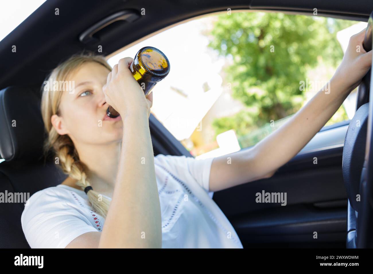 beautiful woman drinking alcohol while driving a car Stock Photo - Alamy