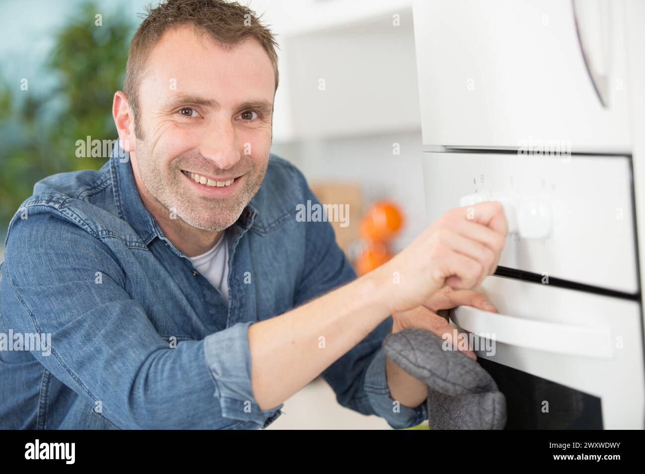man changing temperature on the oven Stock Photo - Alamy