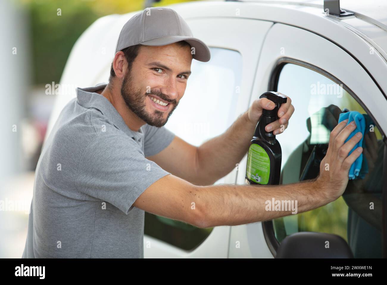 man sprays car shampoo on window from plastic bottle Stock Photo - Alamy
