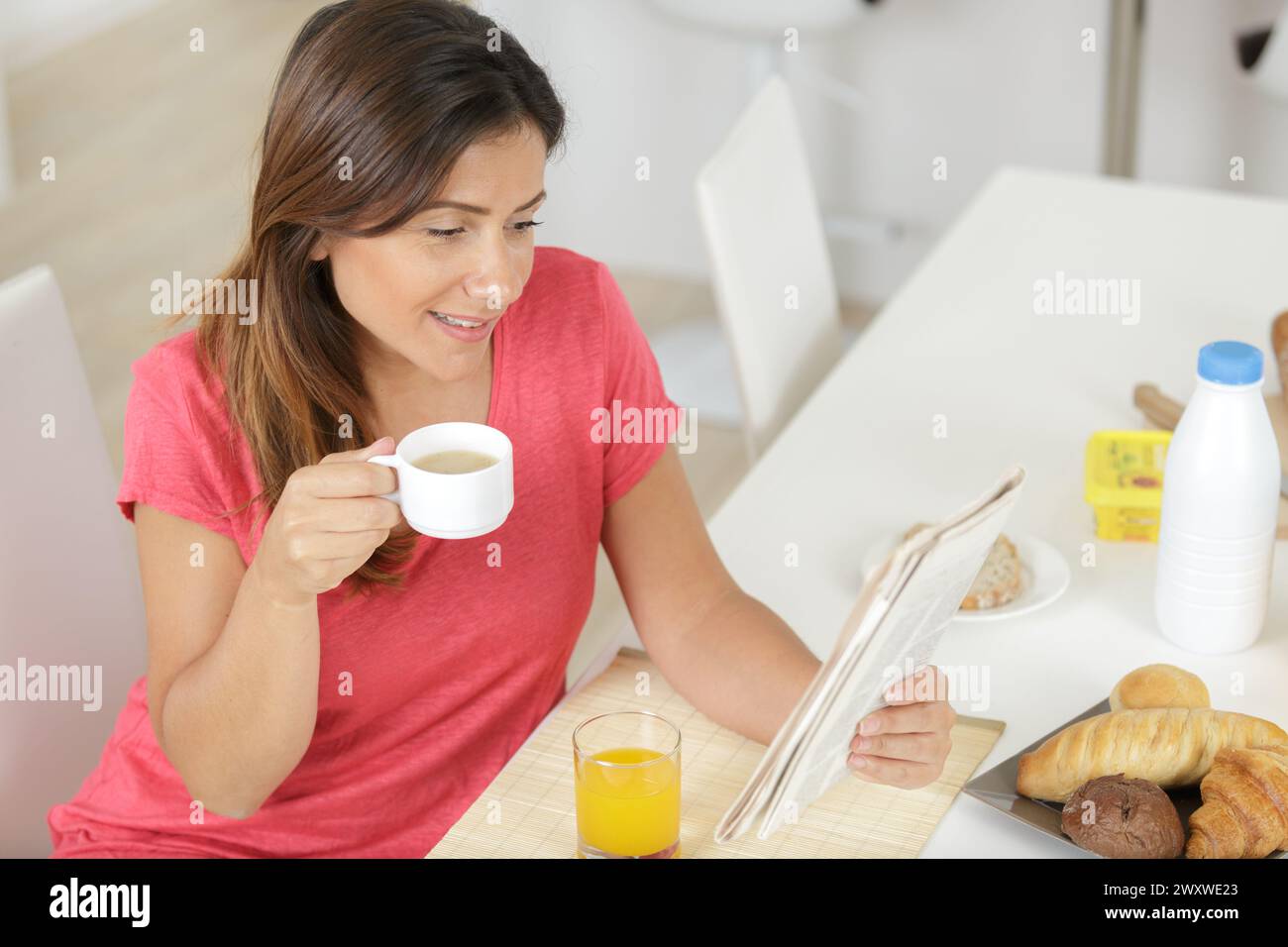 Woman eating breakfast reading newspaper hi-res stock photography and ...