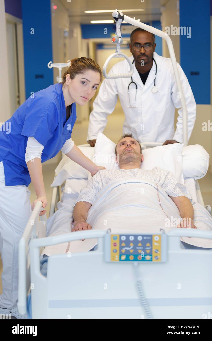 group of doctors carrying man patient on hospital gurney Stock Photo ...