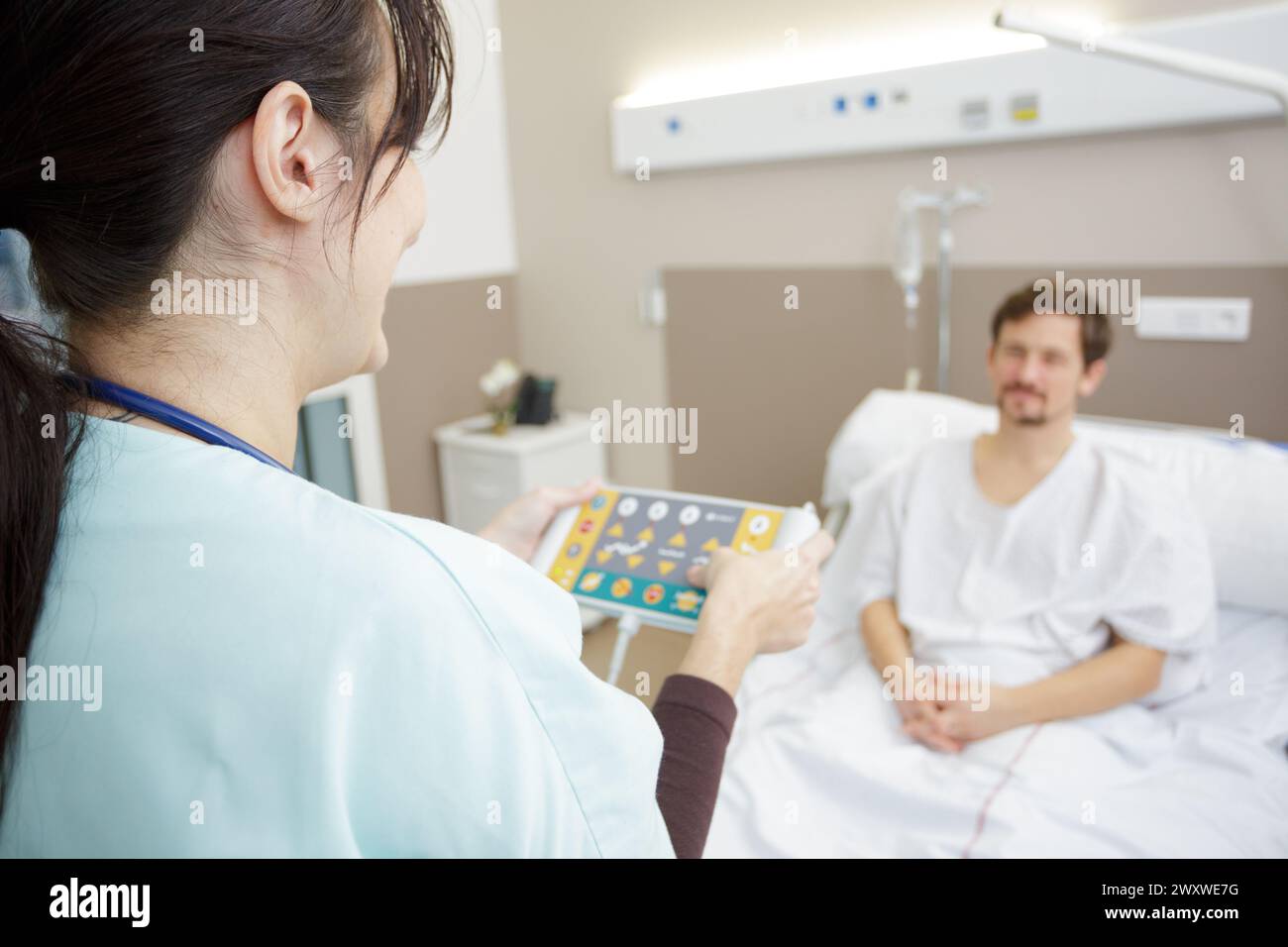 nurse using controls to alter angle of hospital bed Stock Photo - Alamy