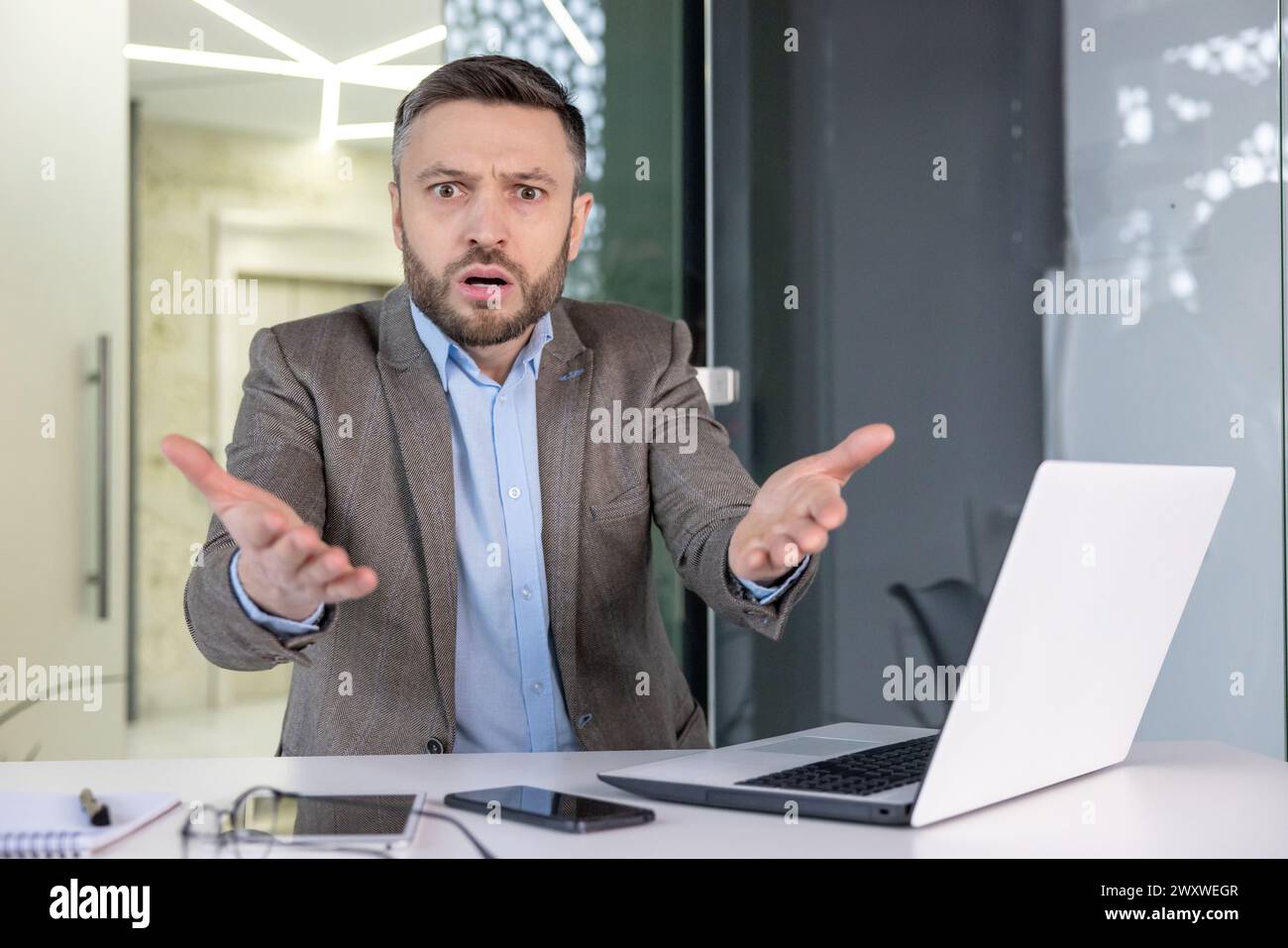 Portrait of a befuddled businessman in an office setting looking ...