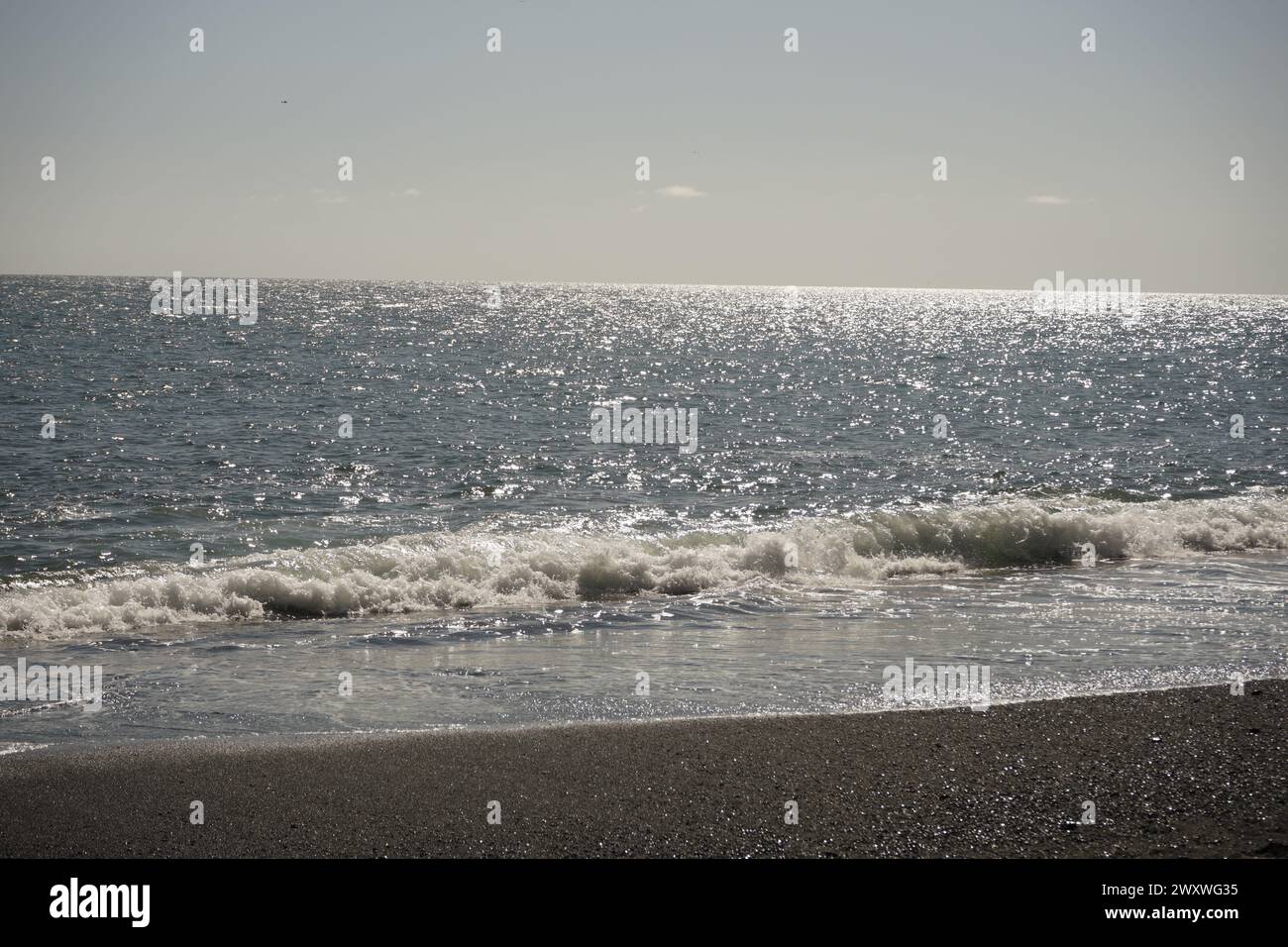 Calm ocean waves break on an empty sandy beach in Skarðsvík, Iceland ...