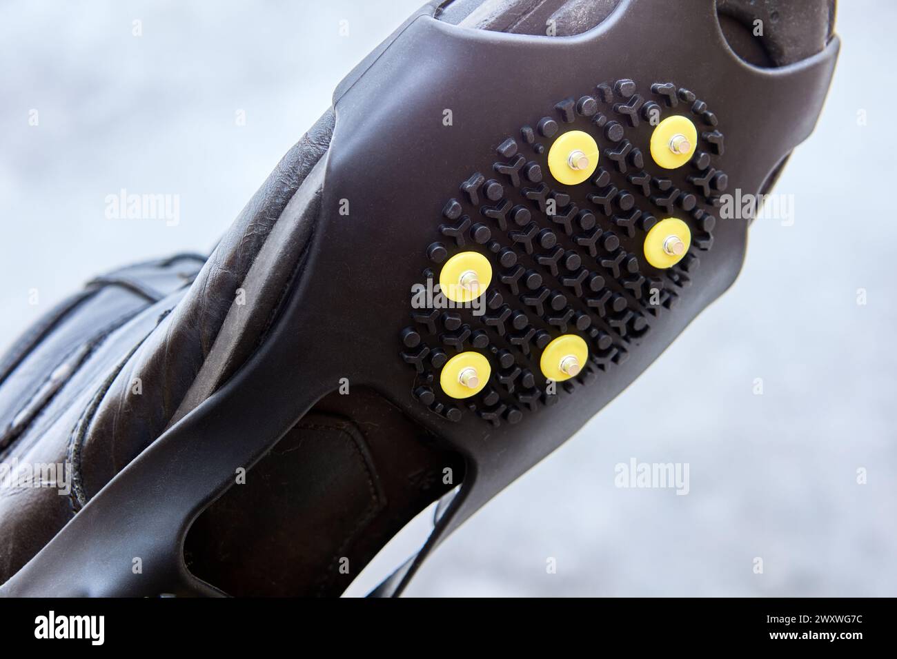 Overlay anti-slip spikes on soles of winter shoes to improve traction ...