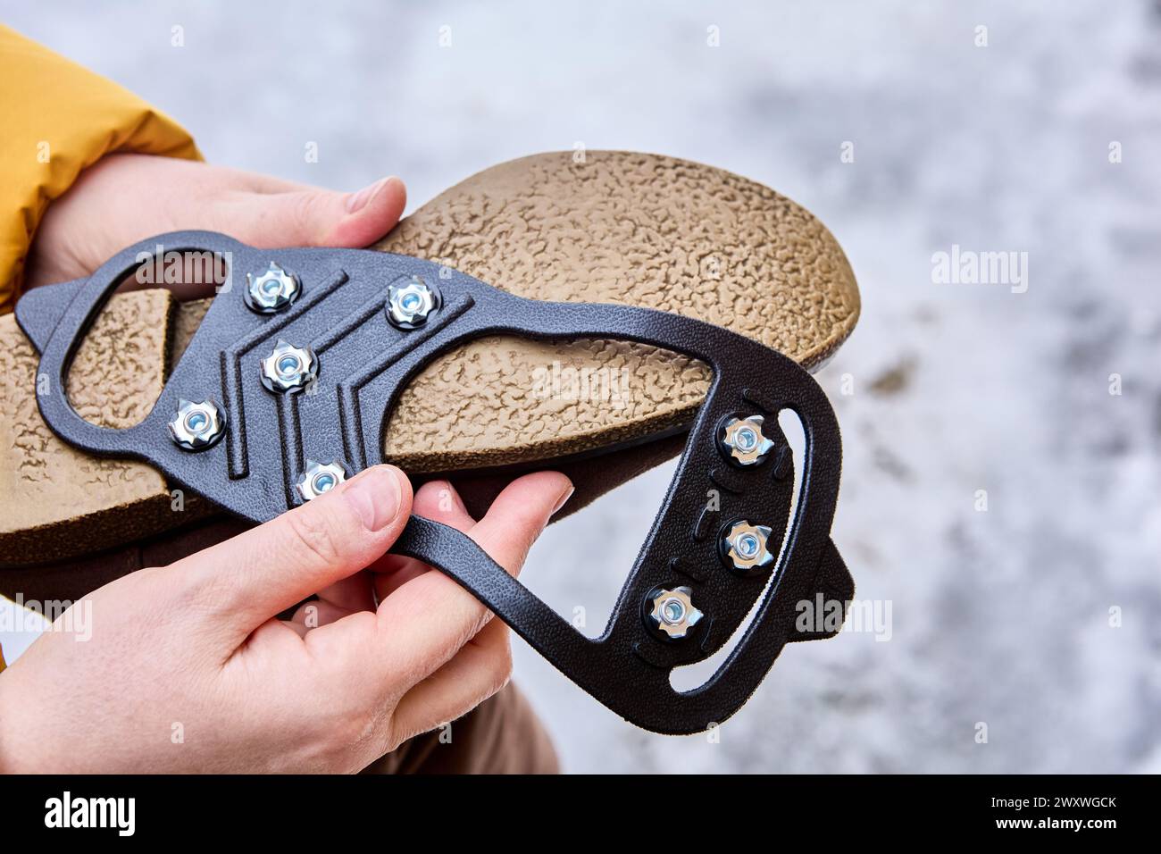 Anti-slip rubber overlay with spikes is attached to winter shoes for ...