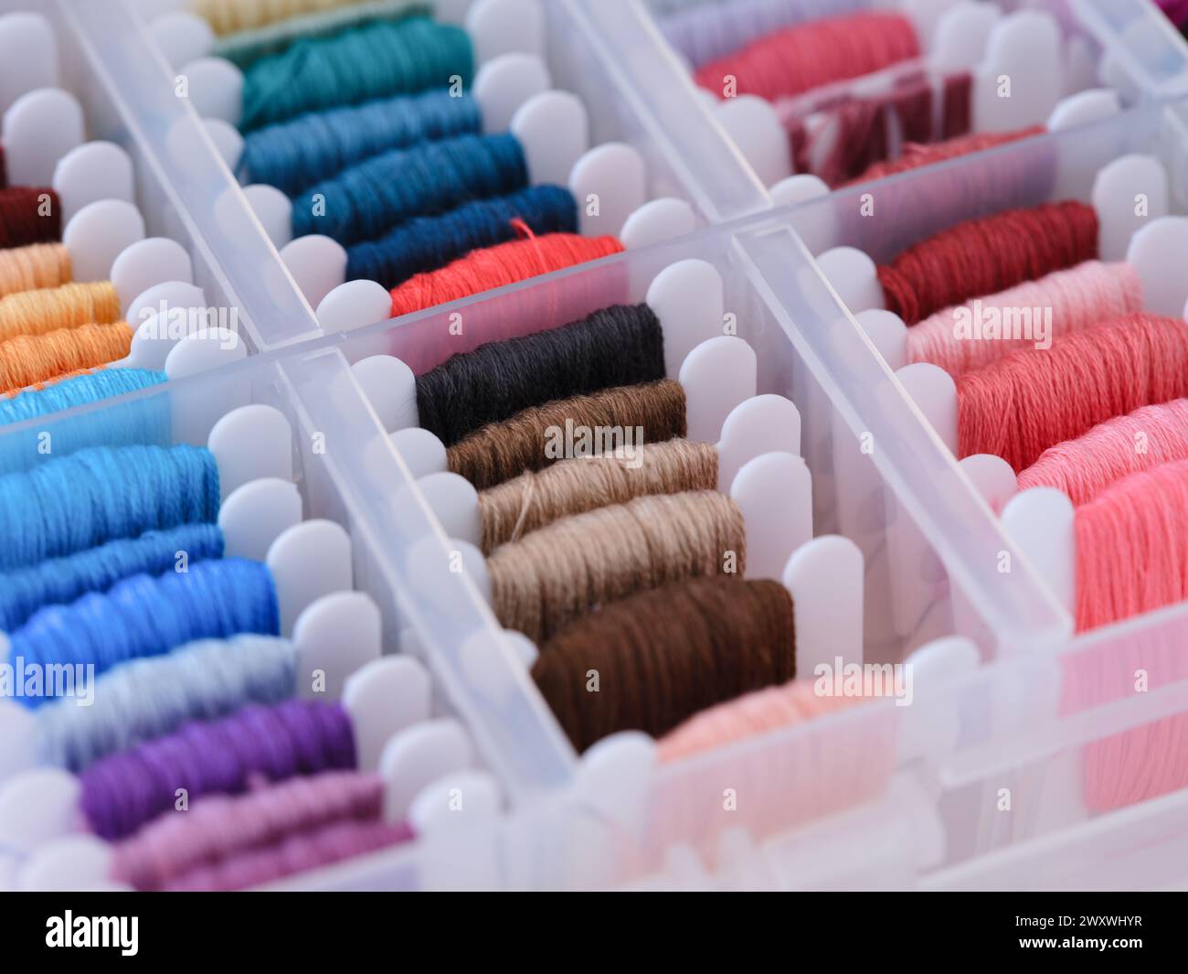 Plastic sorting box full of bobbins with different color embroidery ...