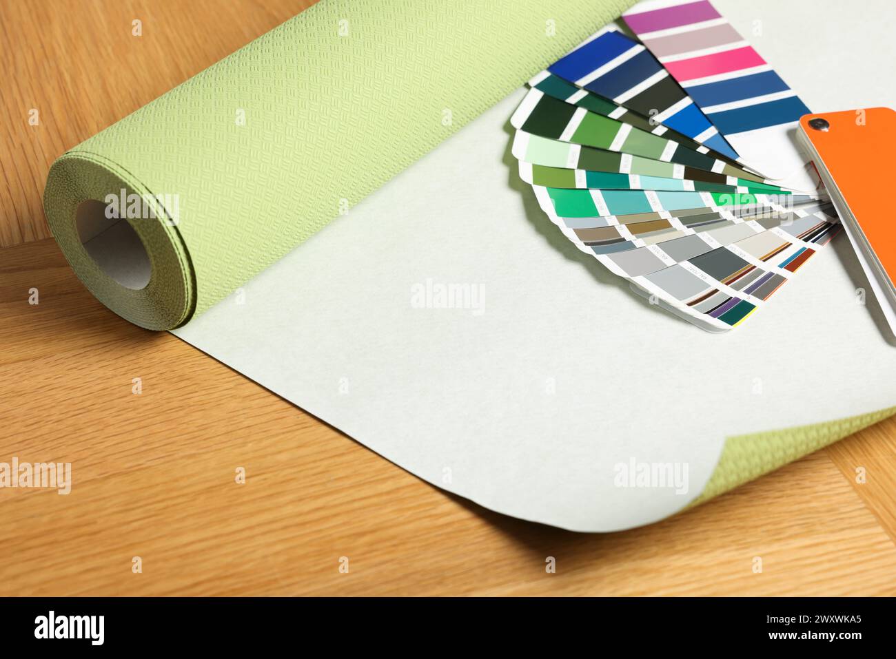 Green wallpaper roll and color palette samples on wooden table Stock ...
