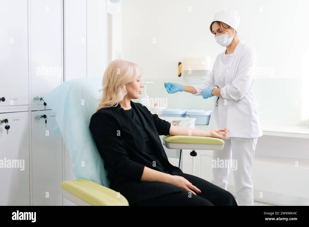 Female nurse in mask and gloves preparing test collection for lady ...