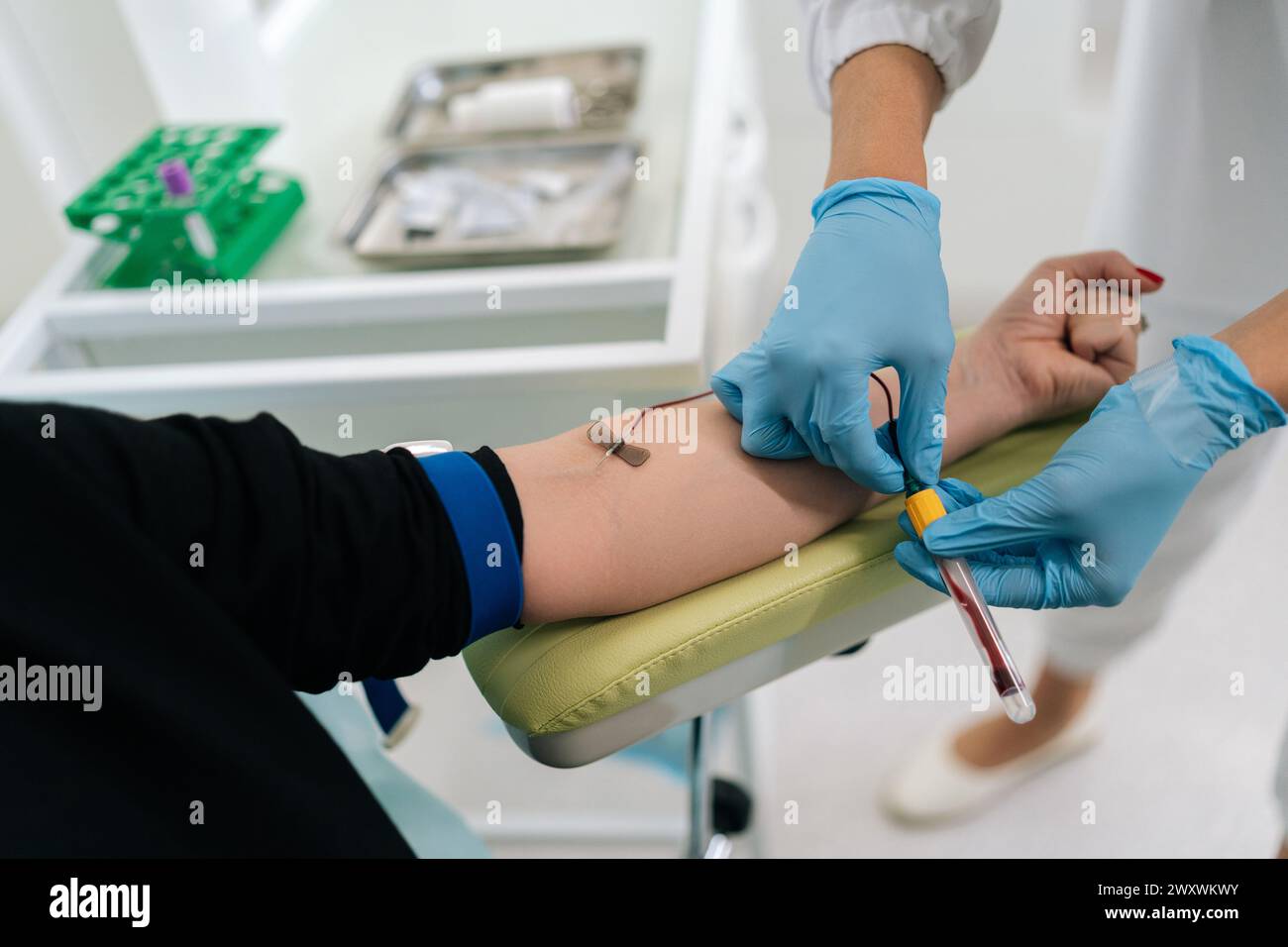 Closeup of female laboratory worker in blue medical gloves collecting ...