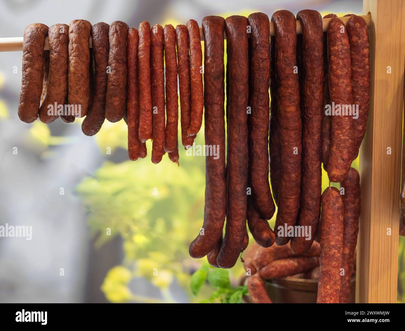 Different types of homemade smoked dry sausages hanging on a dark ...