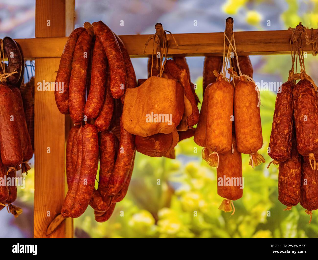Different types of homemade smoked dry sausages hanging on a dark ...
