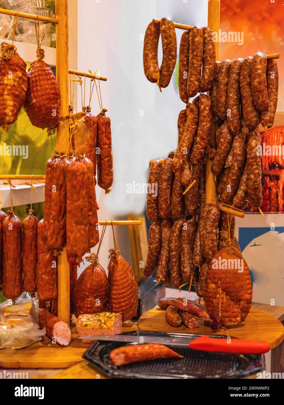 Different types of homemade smoked dry sausages hanging on a dark ...