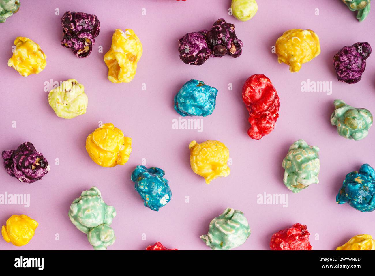 Sweet colorful popcorn on lilac background Stock Photo - Alamy