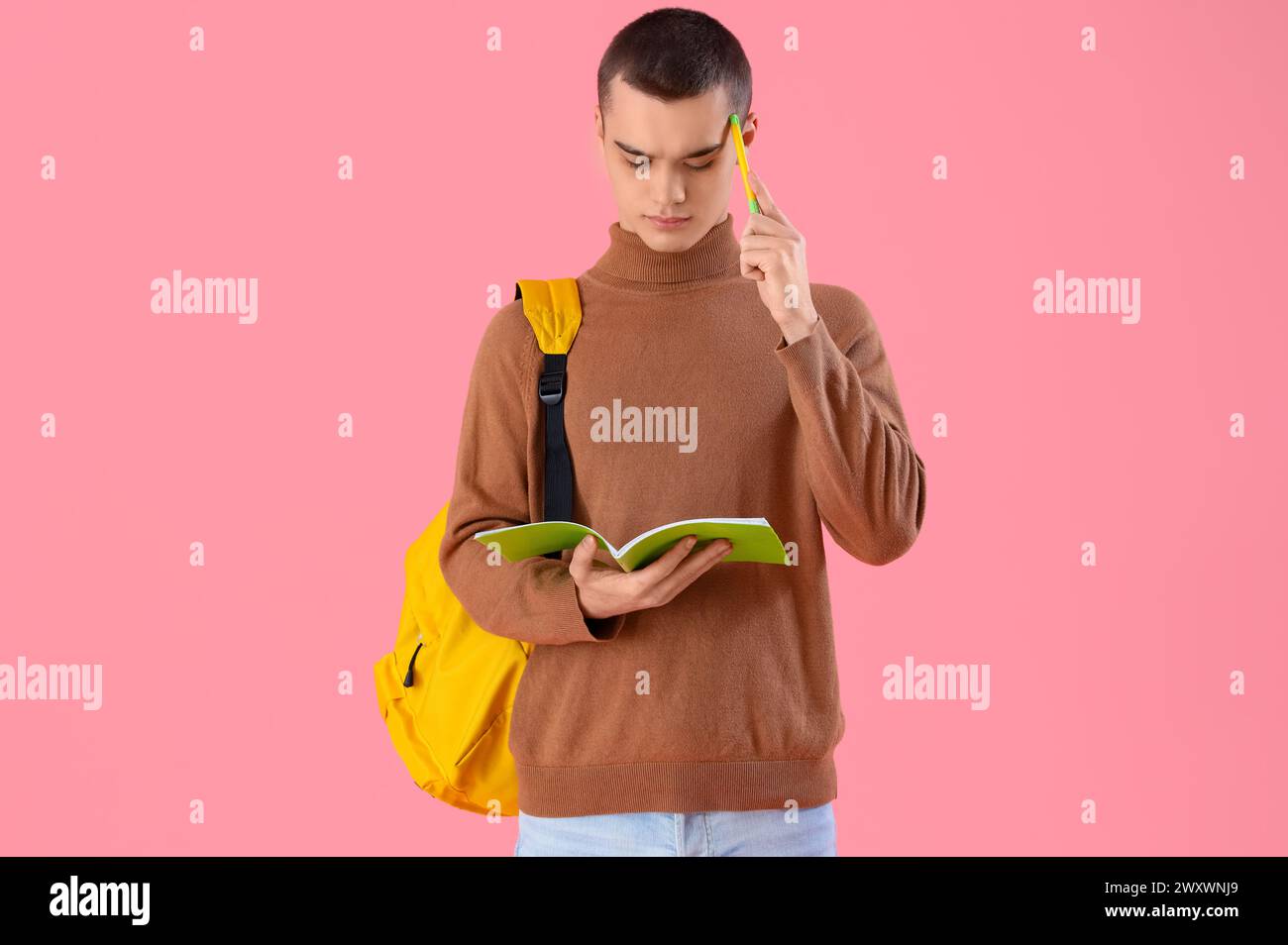 Male student with copybook trying to remember something on pink ...