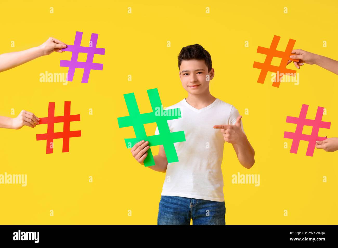 Cute teenage boy and hands with hashtags on yellow background Stock ...
