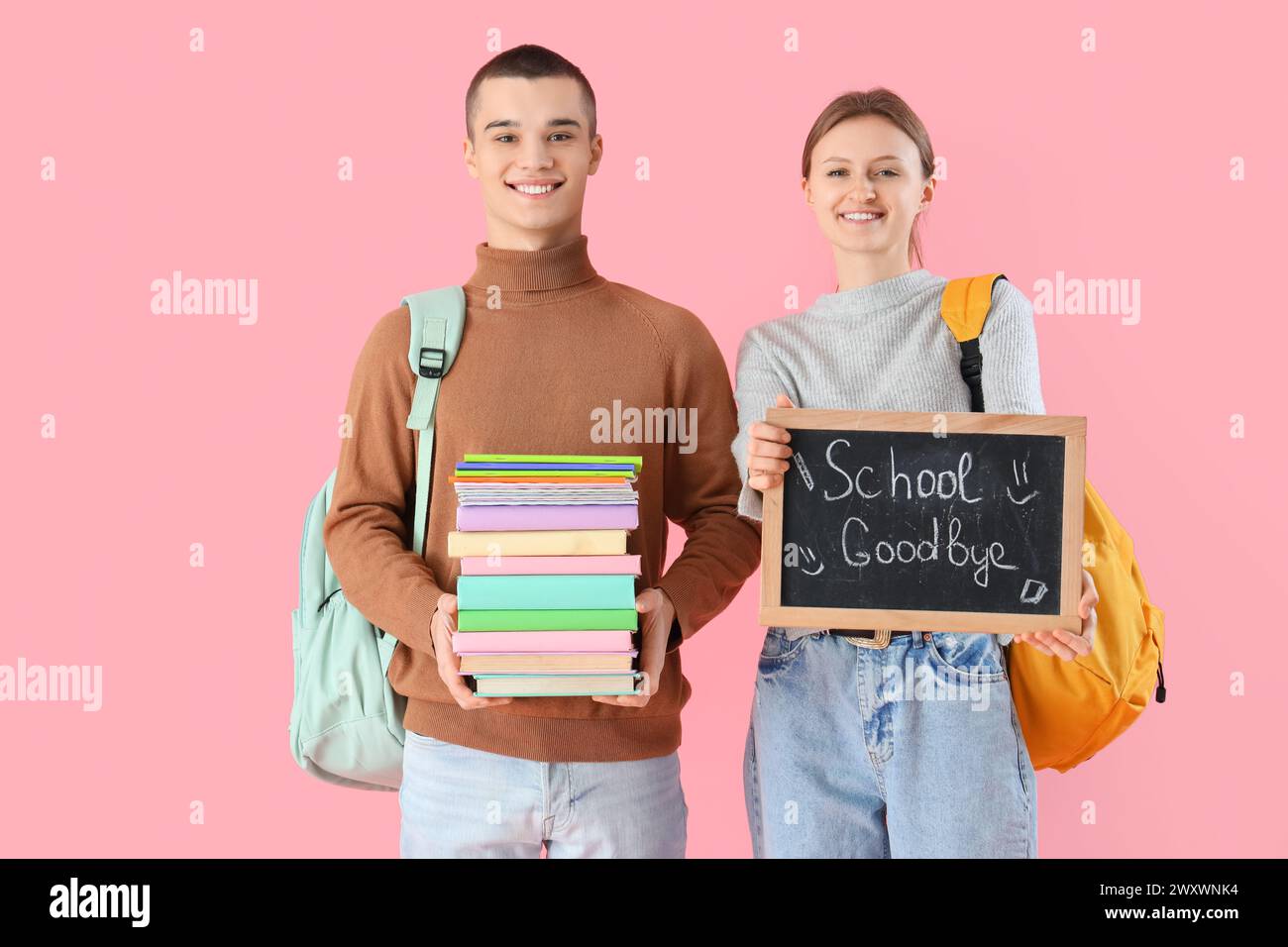 Students holding books and chalkboard with text SCHOOL GOODBYE on pink ...