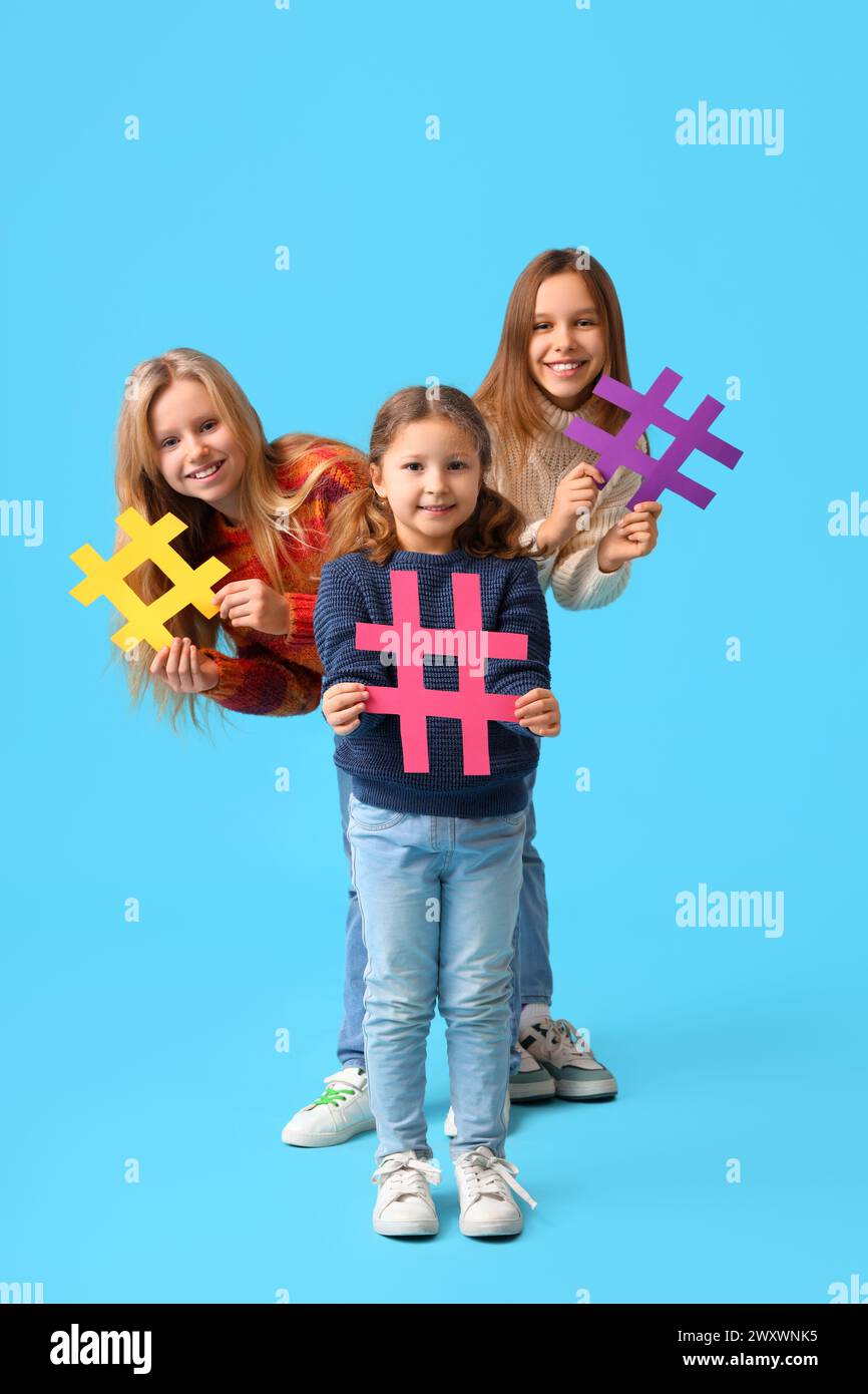 Cute girls with hashtags on blue background Stock Photo - Alamy