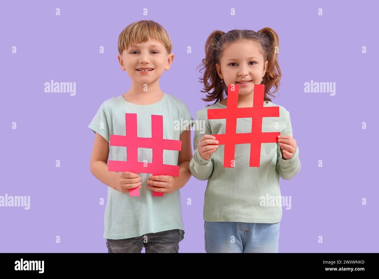 Cute little kids with hashtags on lilac background Stock Photo - Alamy
