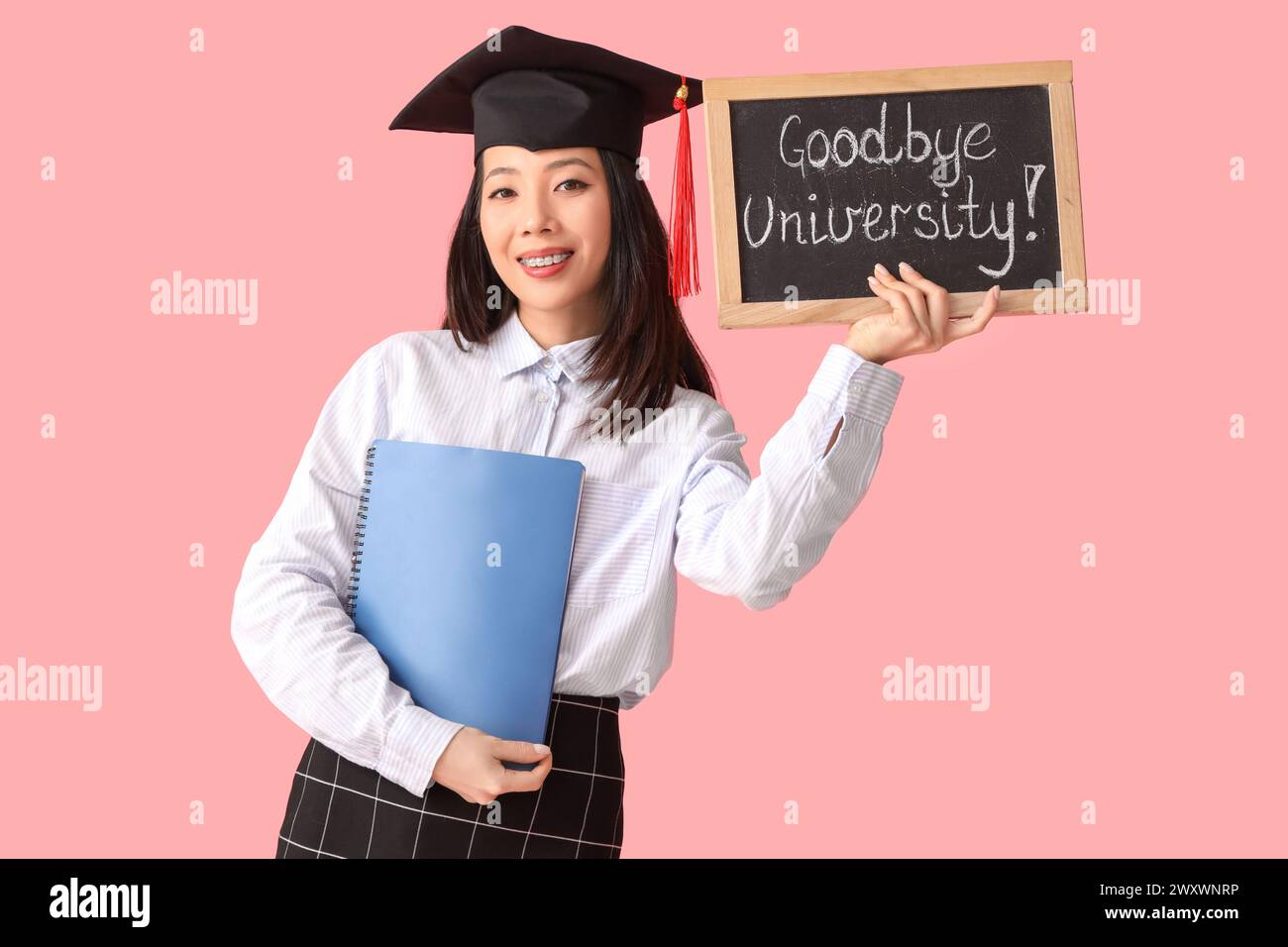 Asian female graduate student holding chalkboard with text GOODBYE ...