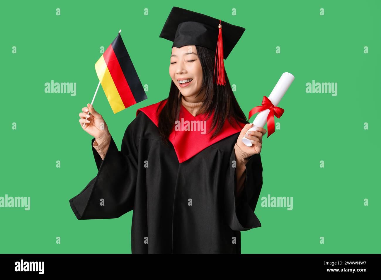 Asian female graduate student with diploma and flag of Germany on green ...