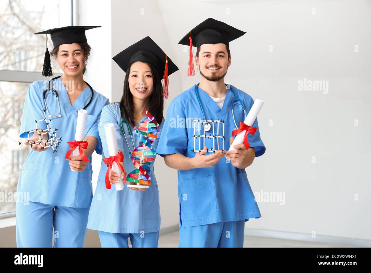 Medical graduate students with diplomas, DNA and molecular models in ...