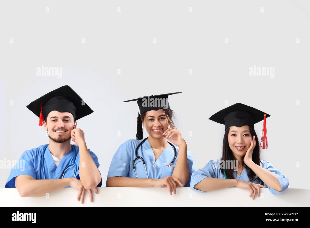 Medical graduate students with blank poster on white background Stock ...