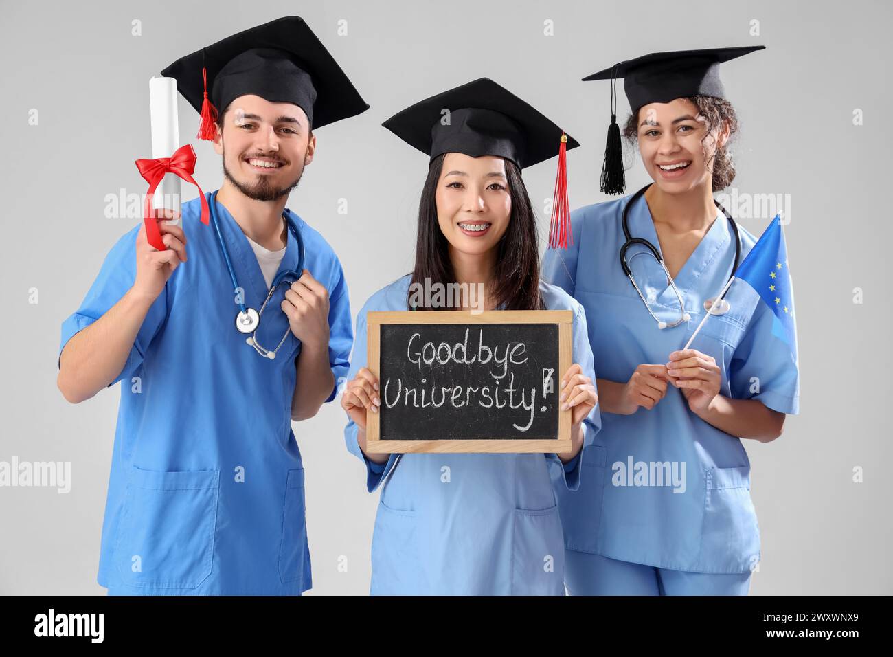 Medical graduate students holding chalkboard with text GOODBYE UNIVERSITY, diploma and EU flag ...