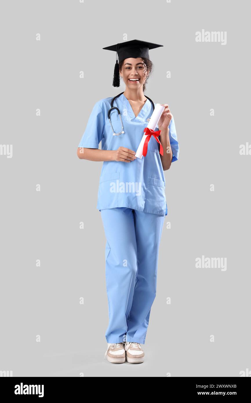 African-American female medical graduate student holding diploma on ...
