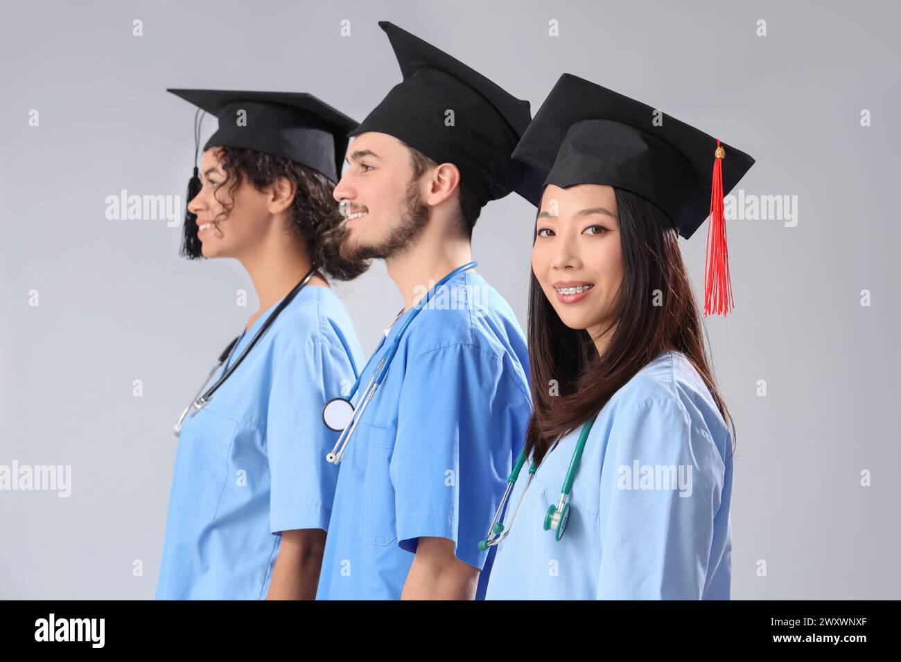 Proud medical graduate students standing in line on white background Stock Photo - Alamy