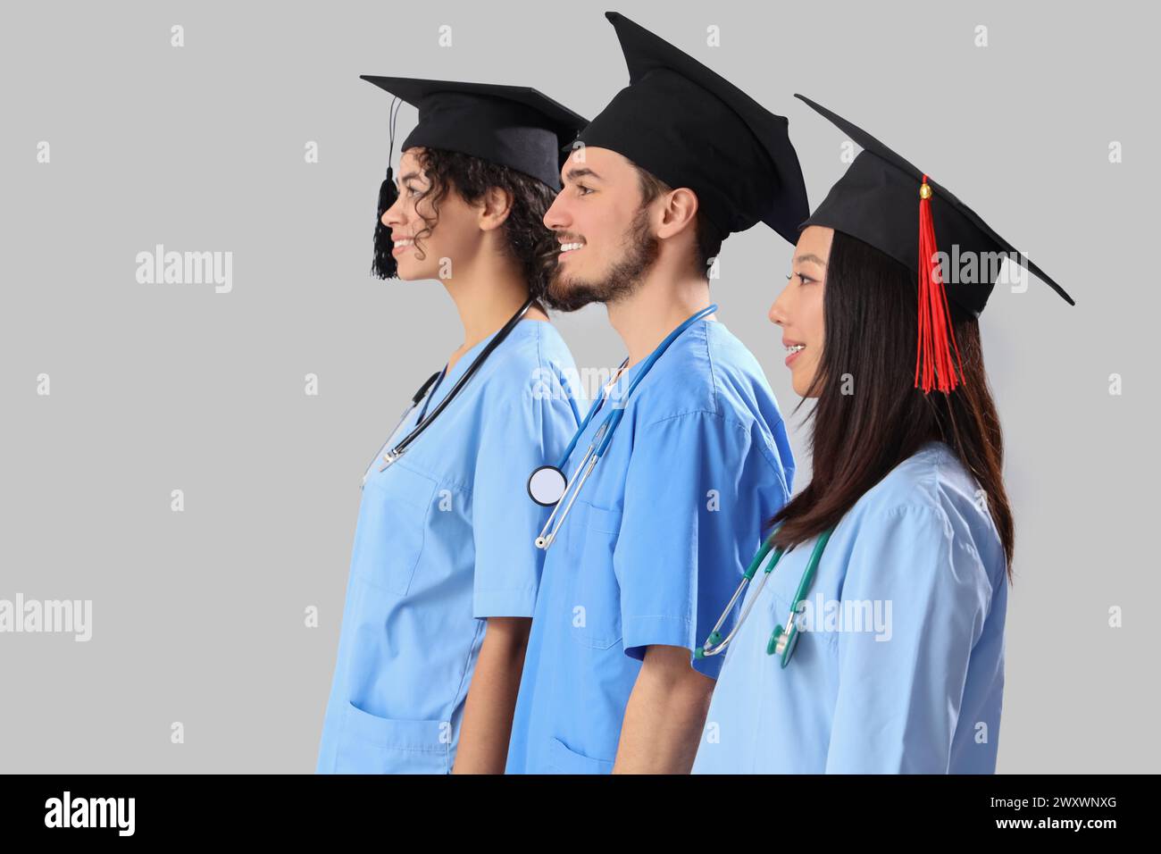 Proud medical graduate students standing in line on white background ...