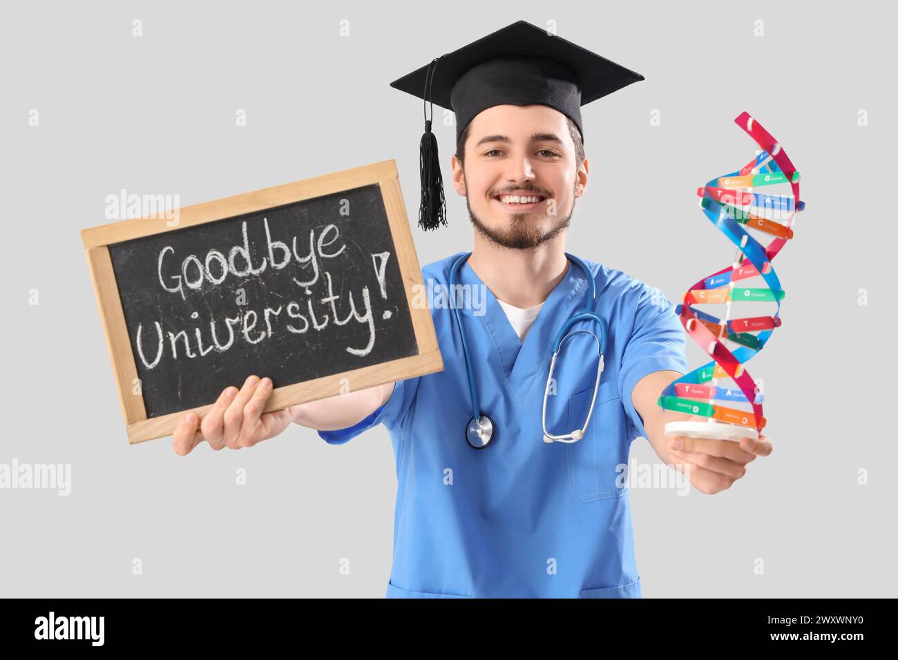 Male medical graduate student holding chalkboard with text GOODBYE ...