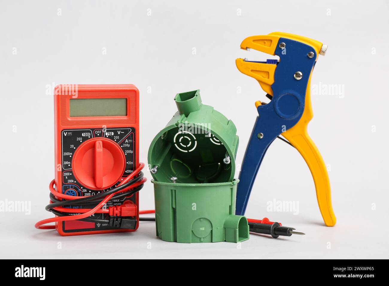 Multimeter, plastic socket boxes and wire stripper on light background ...