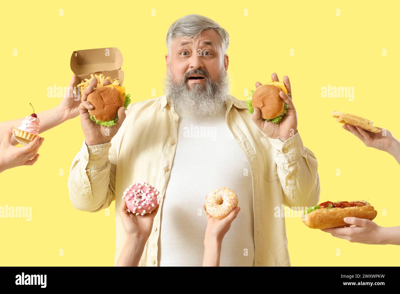 Overweight mature man and hands with unhealthy food on yellow ...