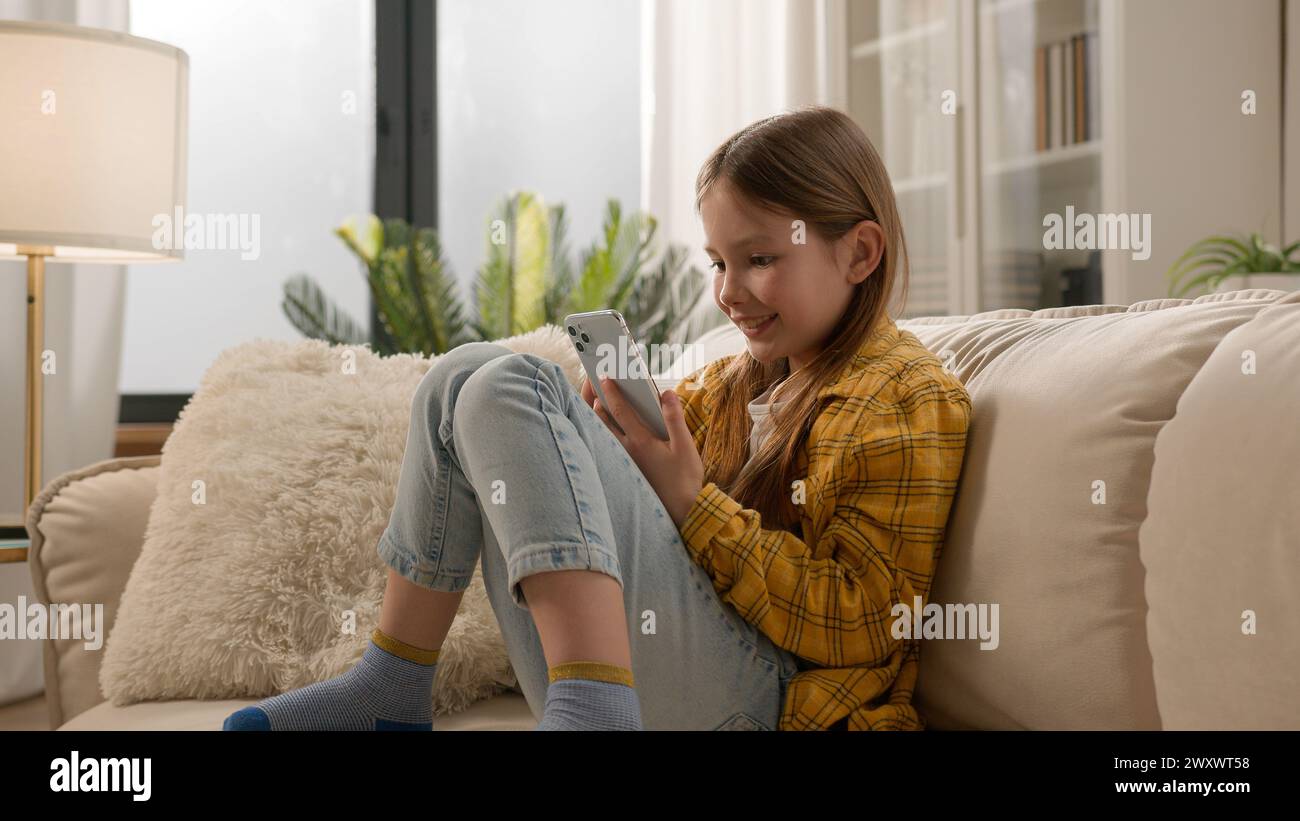 Happy smiling caucasian kid girl child schoolgirl typing message on ...