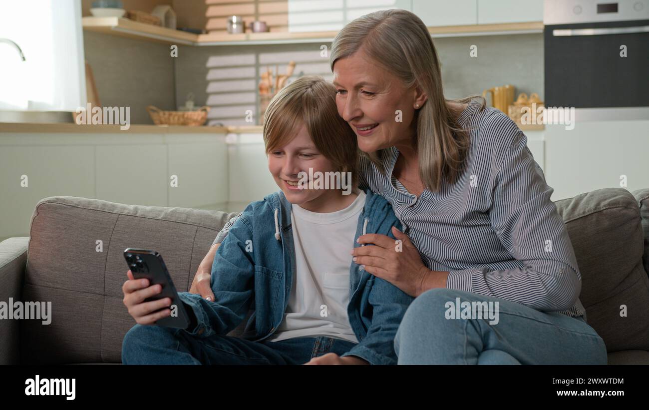 Loving grandmother spending time with grandson together at home mature ...