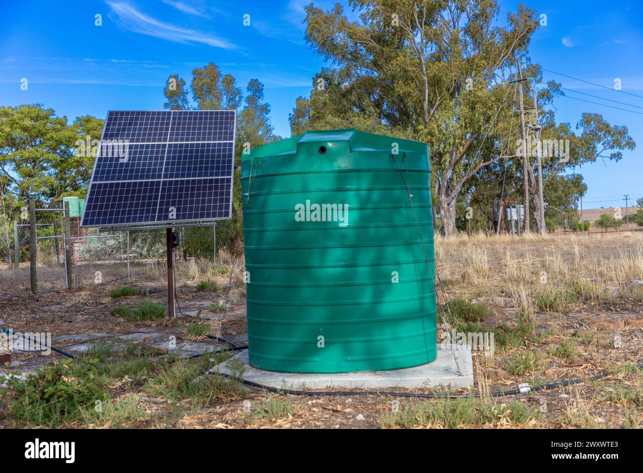 Close up on Solar panels and a large green plastic water tank. Concept ...