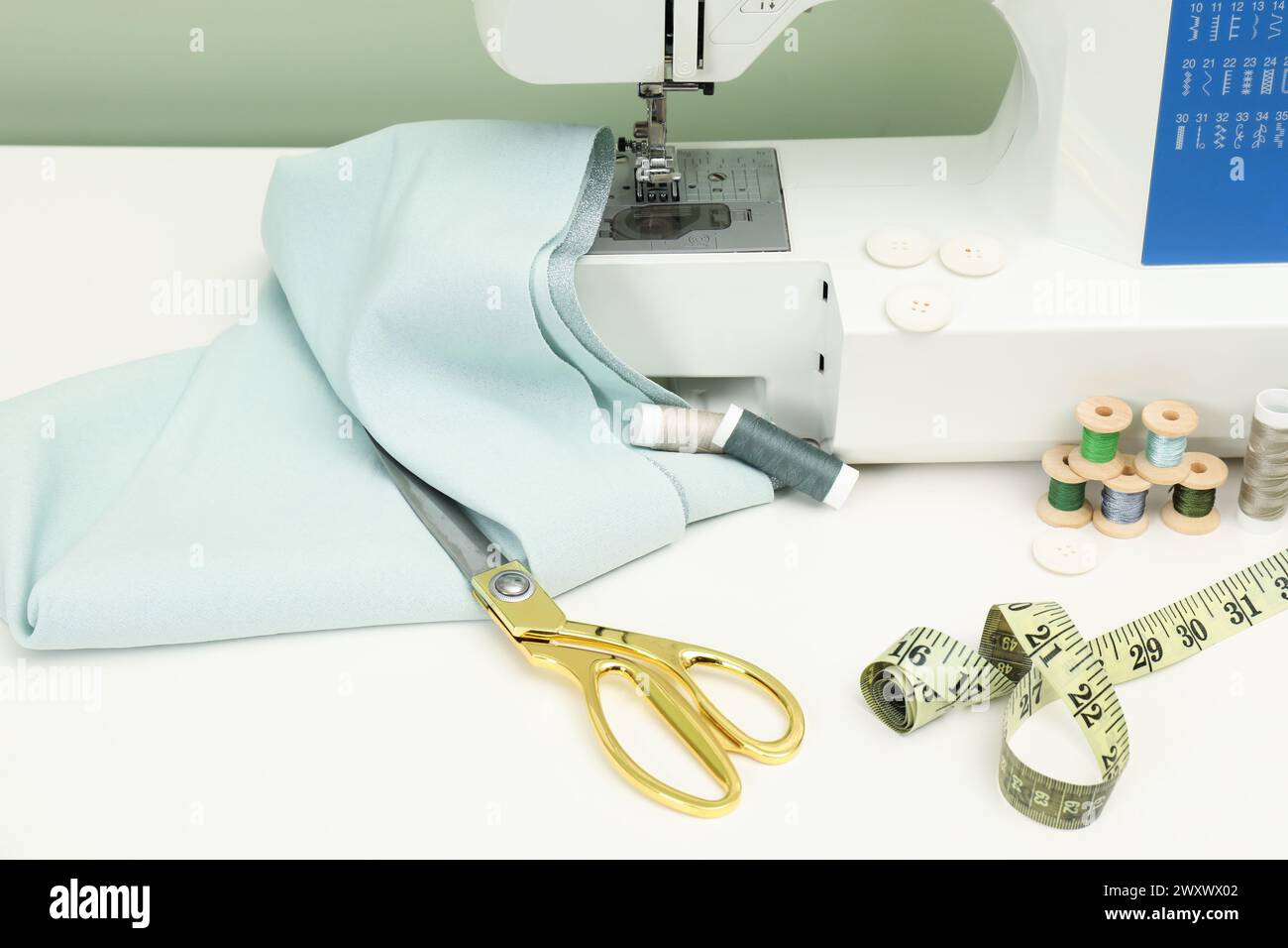 Sewing machine with fabric, scissors, measuring tape and threads on ...