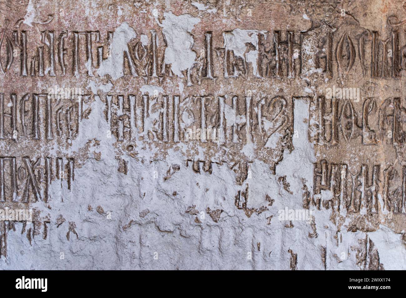 Ancient religious inscriptions on a dilapidated stone wall. Background ...
