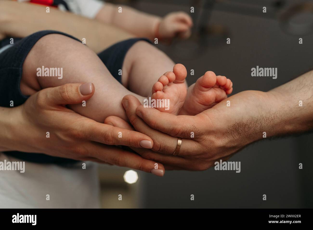Mother hands holding baby feet hi-res stock photography and images - Alamy