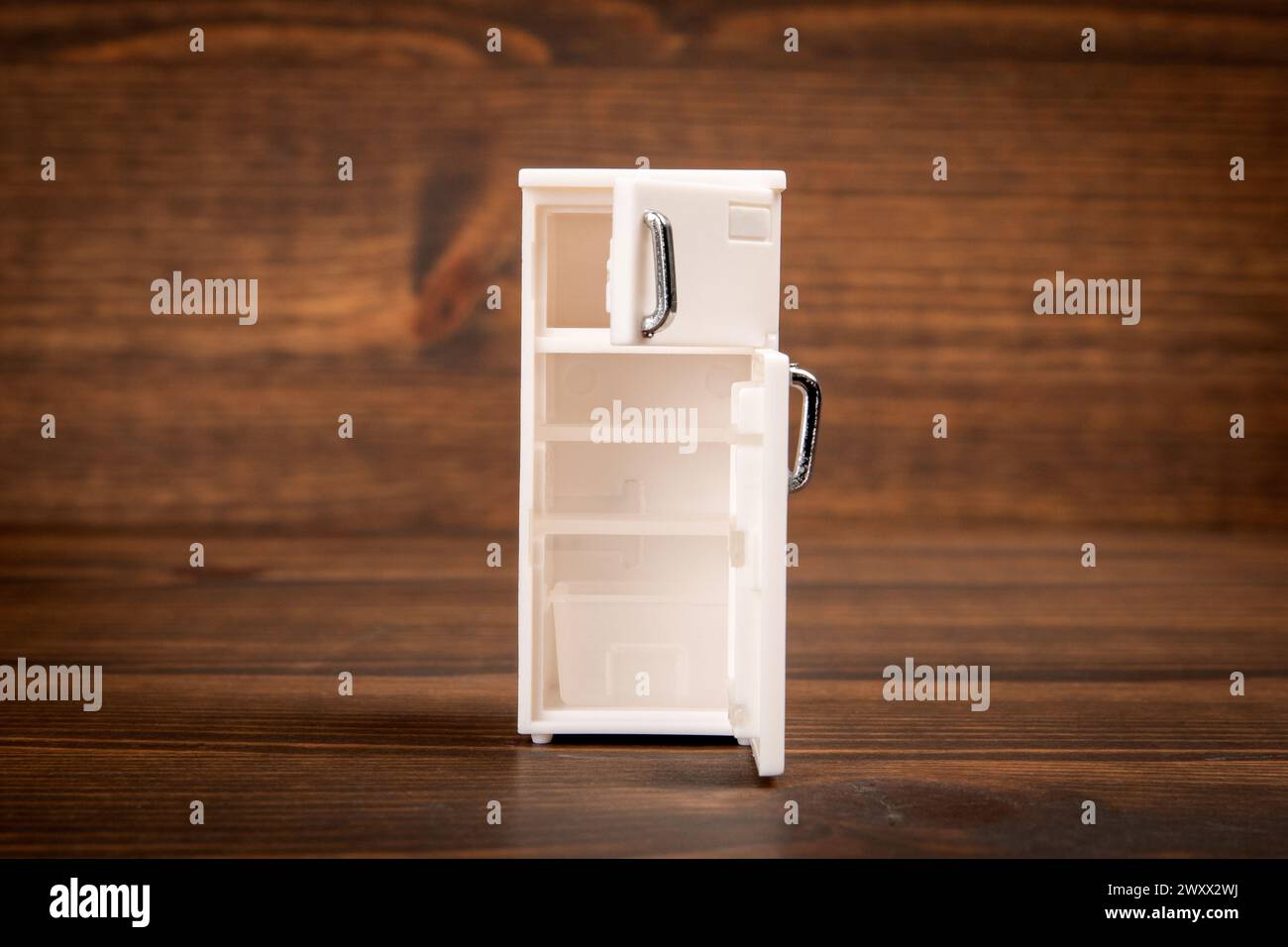 White miniature refrigerator on wood texture background. Food and ...