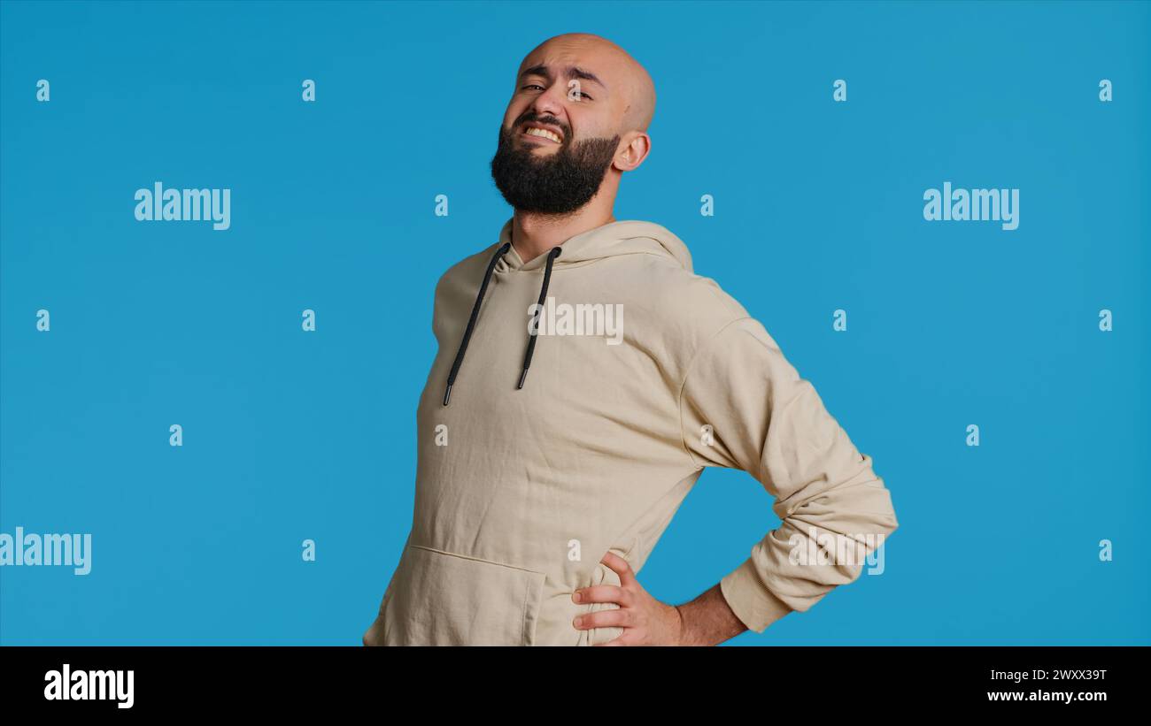 Middle eastern model dealing with lower back pain, having sore muscles ...