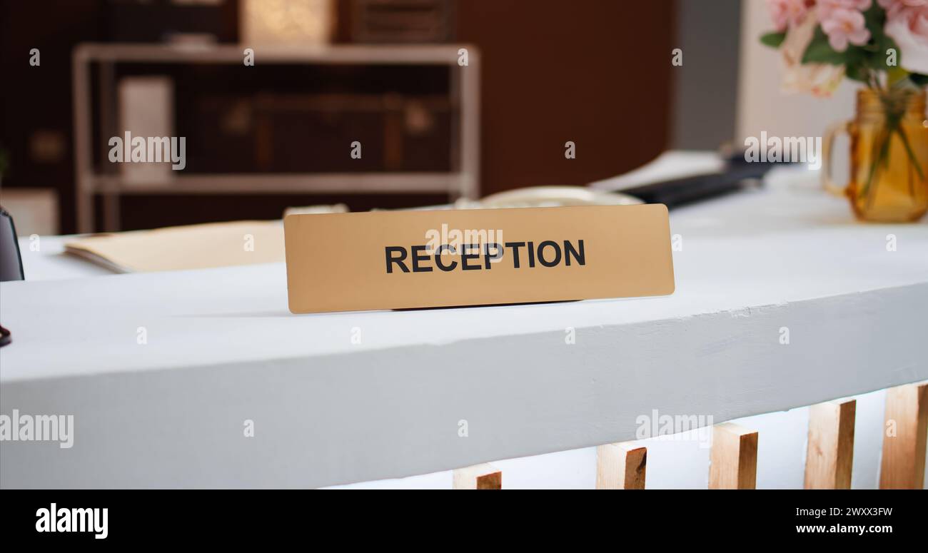 Reception sign placed on front desk in hotel lobby indicating place to ...