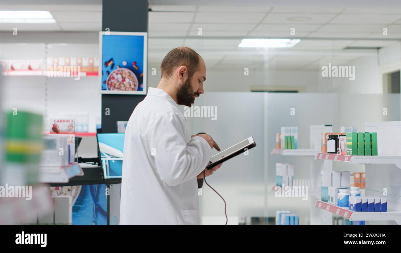 Pharmacy clerk inspects supply of pharmaceuticals on aisles, scanning ...