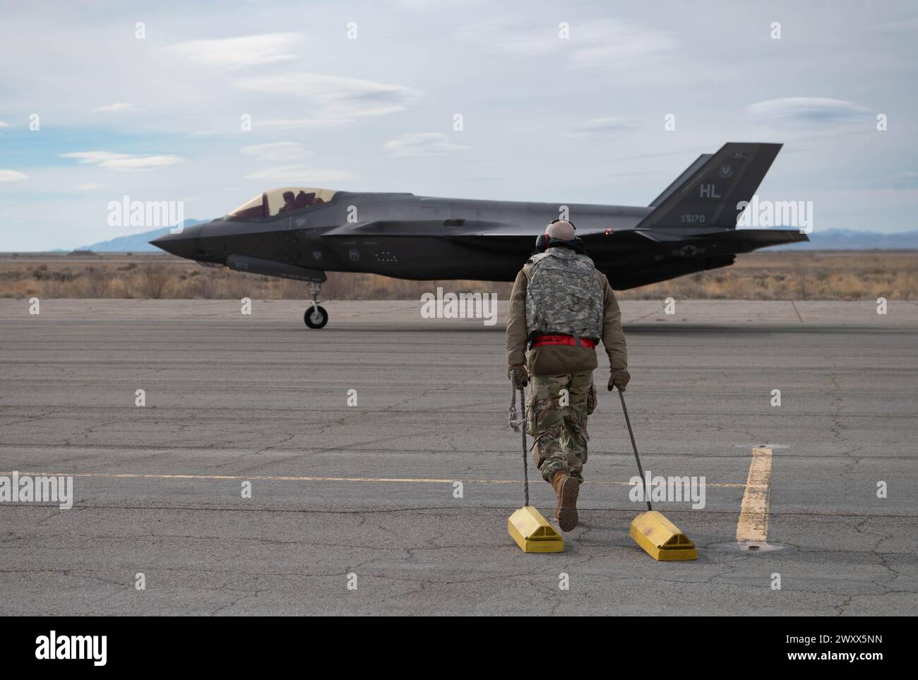 An Airman from the 388th Fighter Wing, runs chalks out to a taxiing F ...