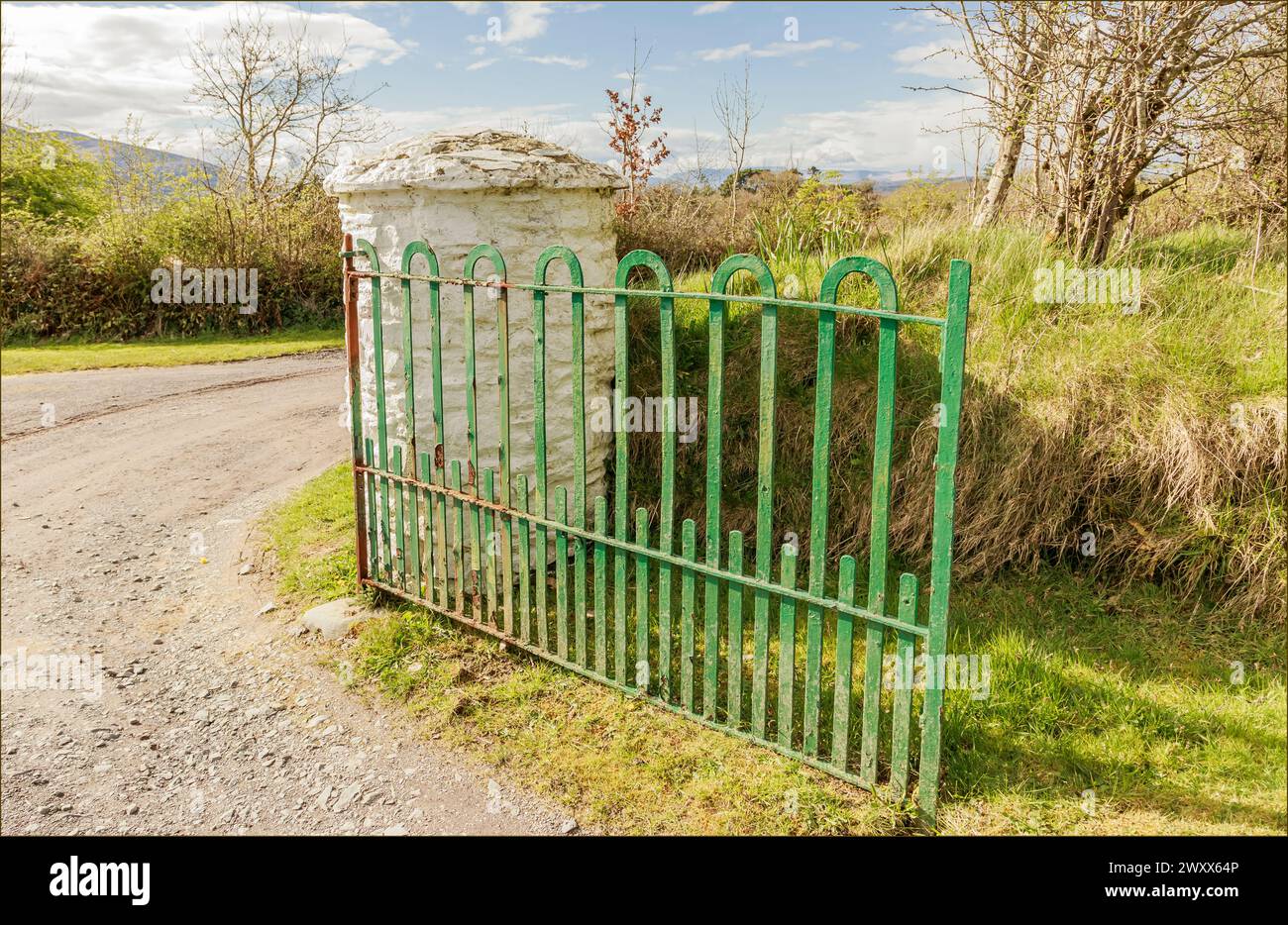 Green painted open metal gate on a white painted stone pillar Stock ...