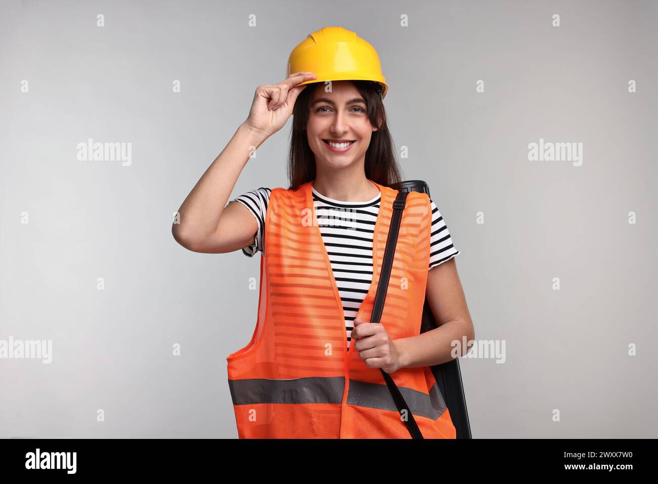 Architect in hard hat with tube on light grey background Stock Photo ...